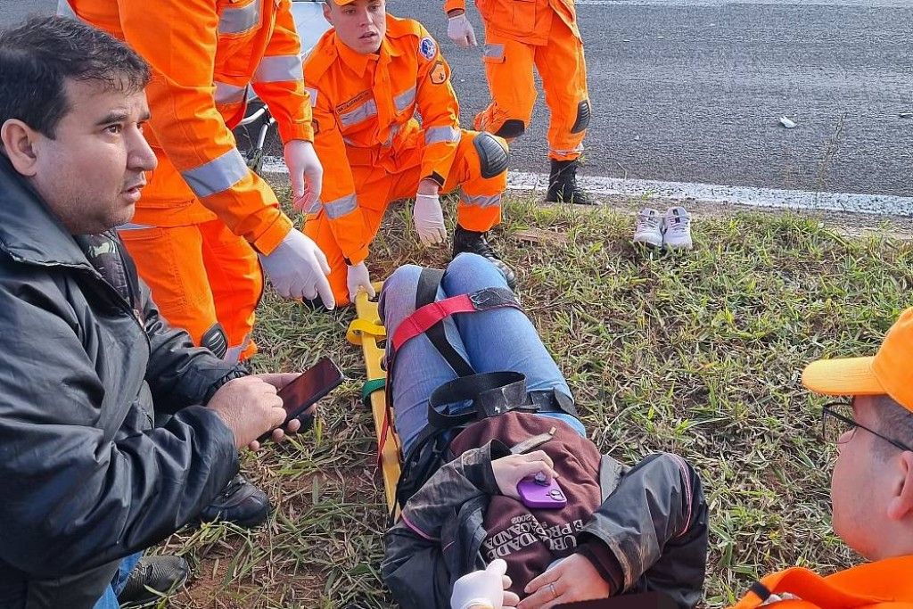 Jovem é socorrida com ferimentos após colisão de moto e caminhão na BR-459